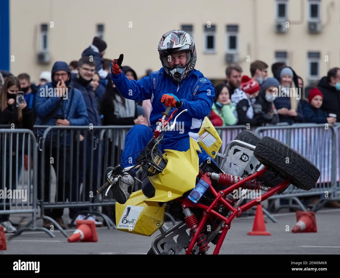 A stuntman rides on two side wheels on an ATV as he greets the audience ...