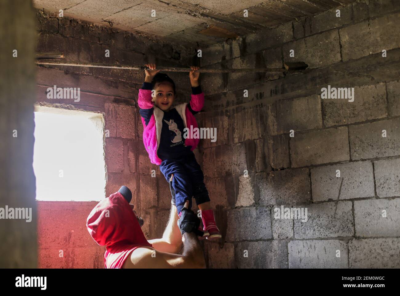 A Palestinian bodybuilder training with his kid at home amid the ...