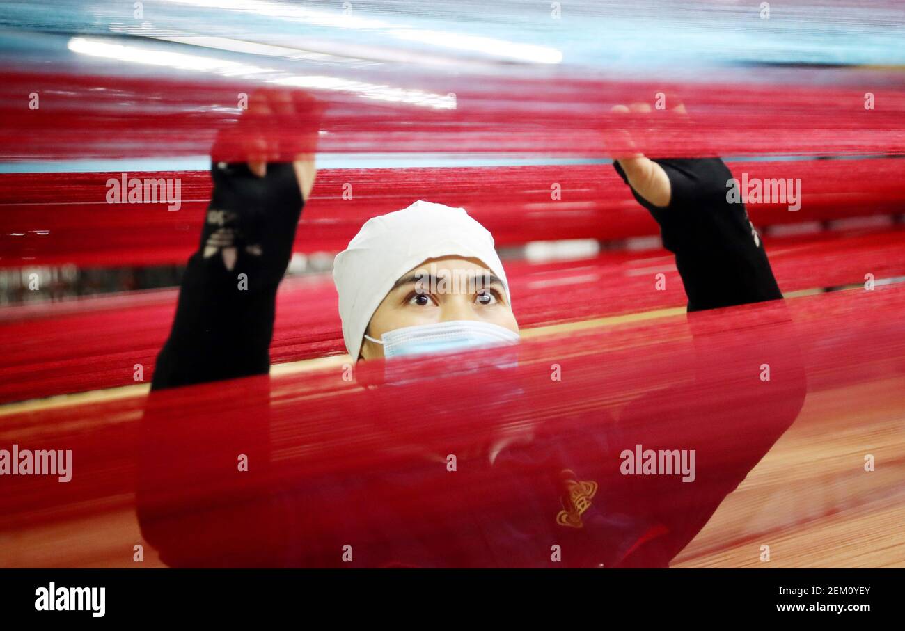 Local workers, standing along the production line, are busy at ...