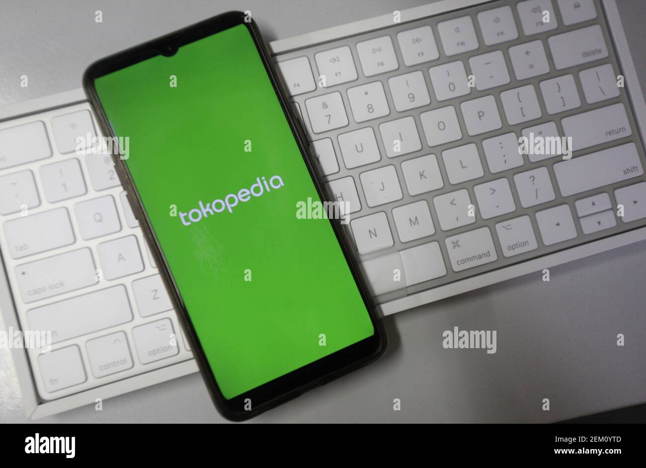 In this photo illustration, a mobile phone featuring the Tokopedia logo ...