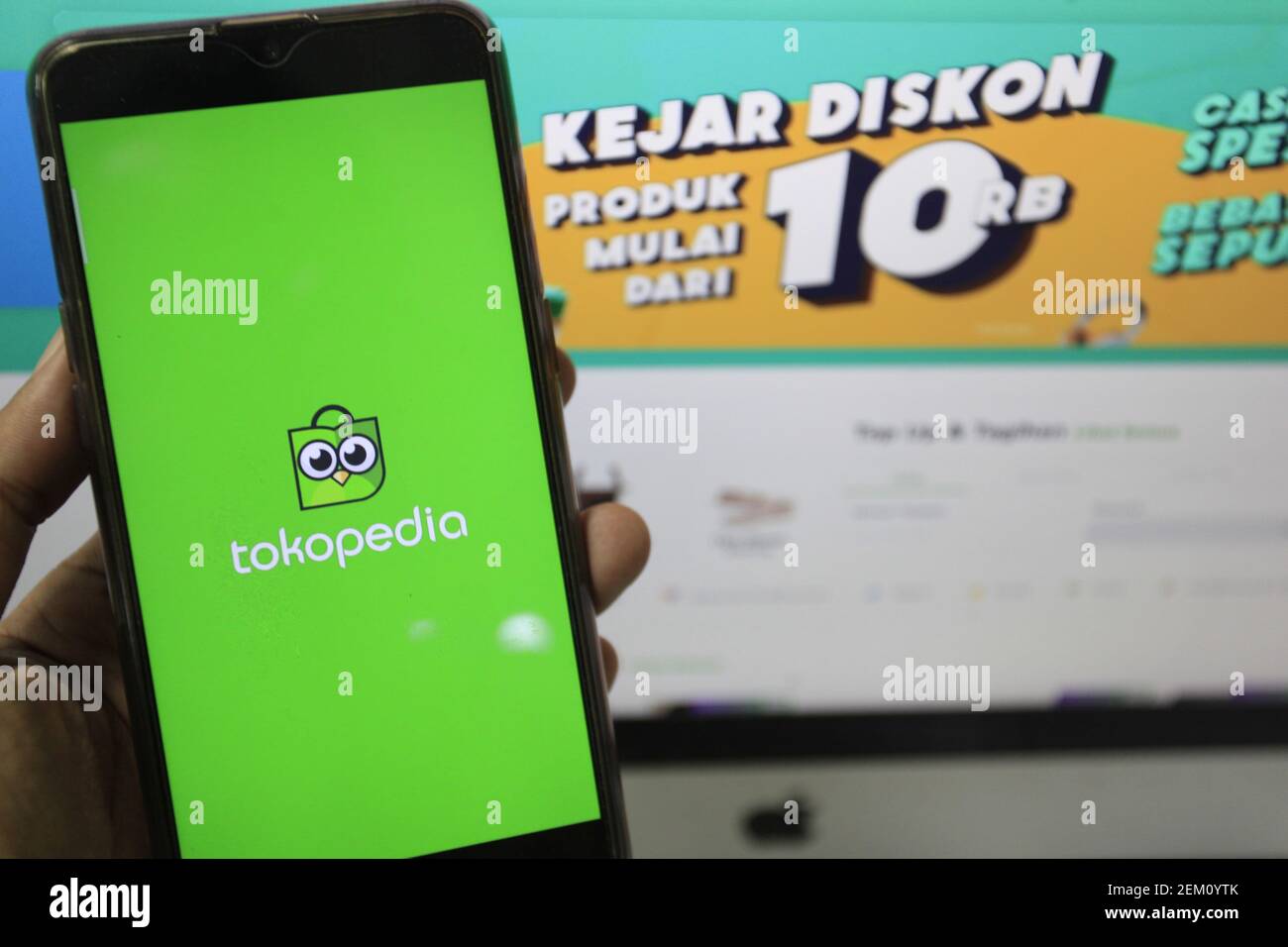 In this photo illustration, a mobile phone featuring the Tokopedia logo ...