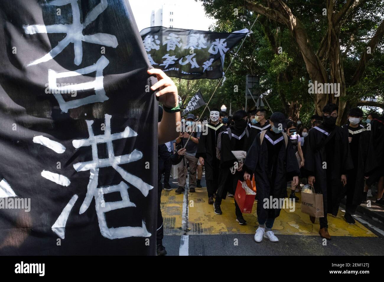 Graduating students hold a flag reading "Liberate Hong Kong, the ...