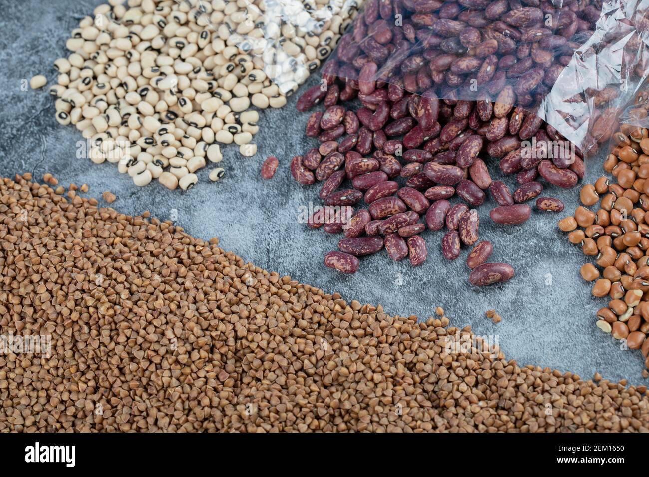 Different kinds of raw beans on a marble background Stock Photo - Alamy