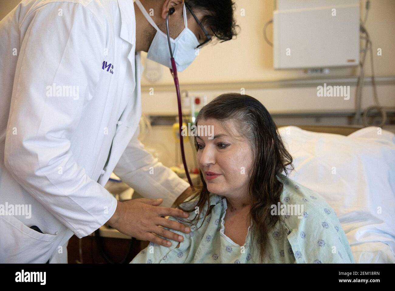 El doctor Ankit Bharat escucha los pulmones de la enfermera Kari Wegg ...