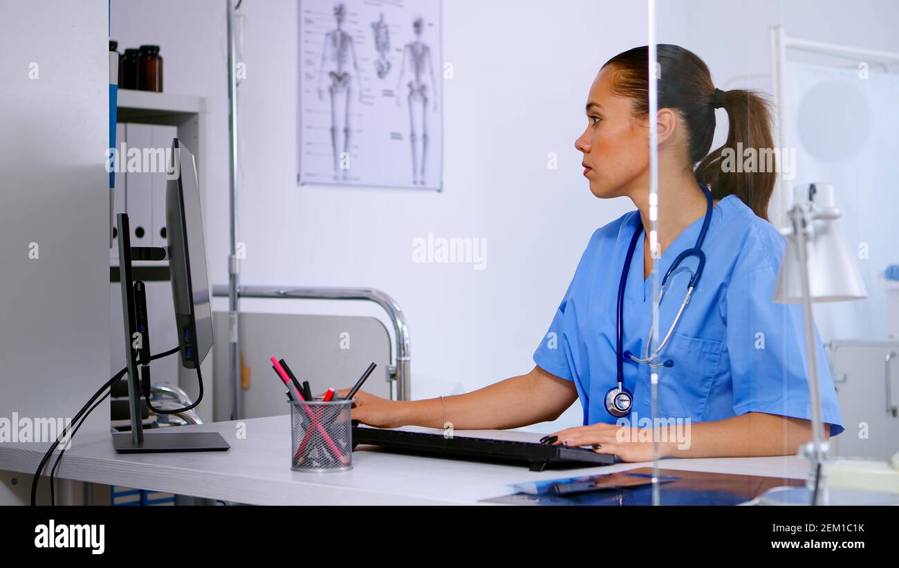 Medical woman nurse typing on computer patient health report, sitting ...