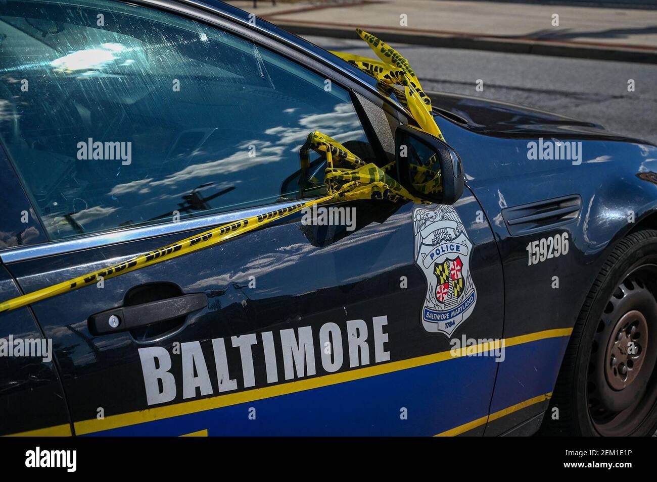 Crime scene tape is wrapped around a Baltimore Police cruiser. (Photo ...