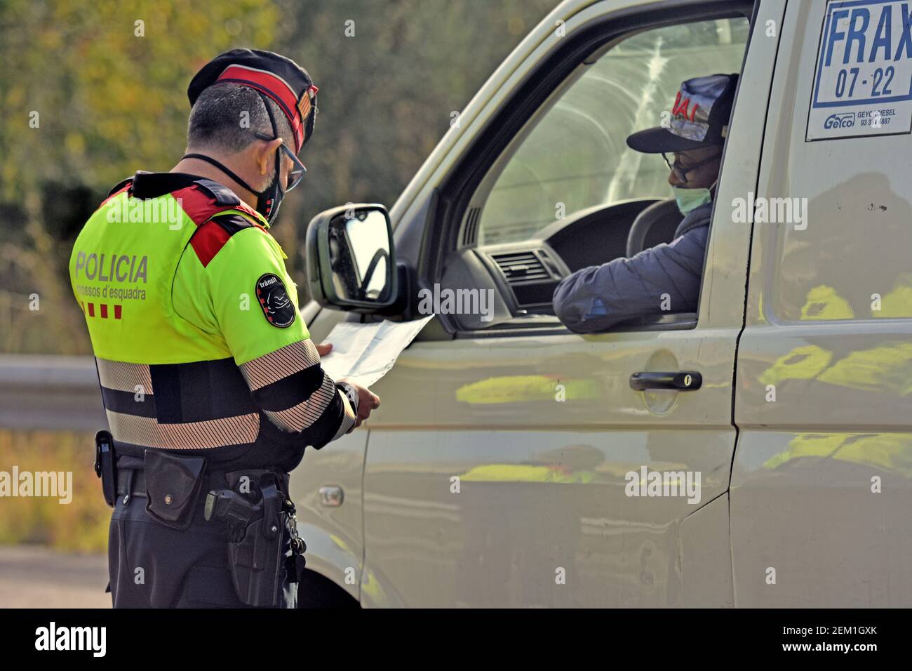 A Catalonia police officer inspects the mobility certificate of a ...