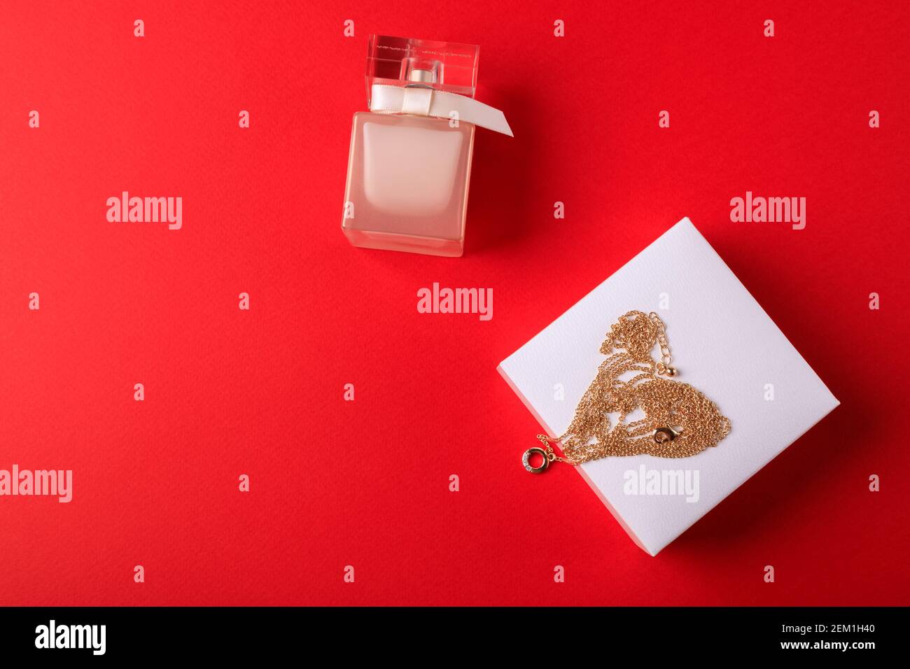 A gift for Valentine's Day. Perfume and a box with a gold chain on a ...