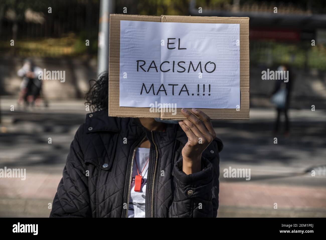 A protester holds a placard against racism during the demonstration. Ca ...