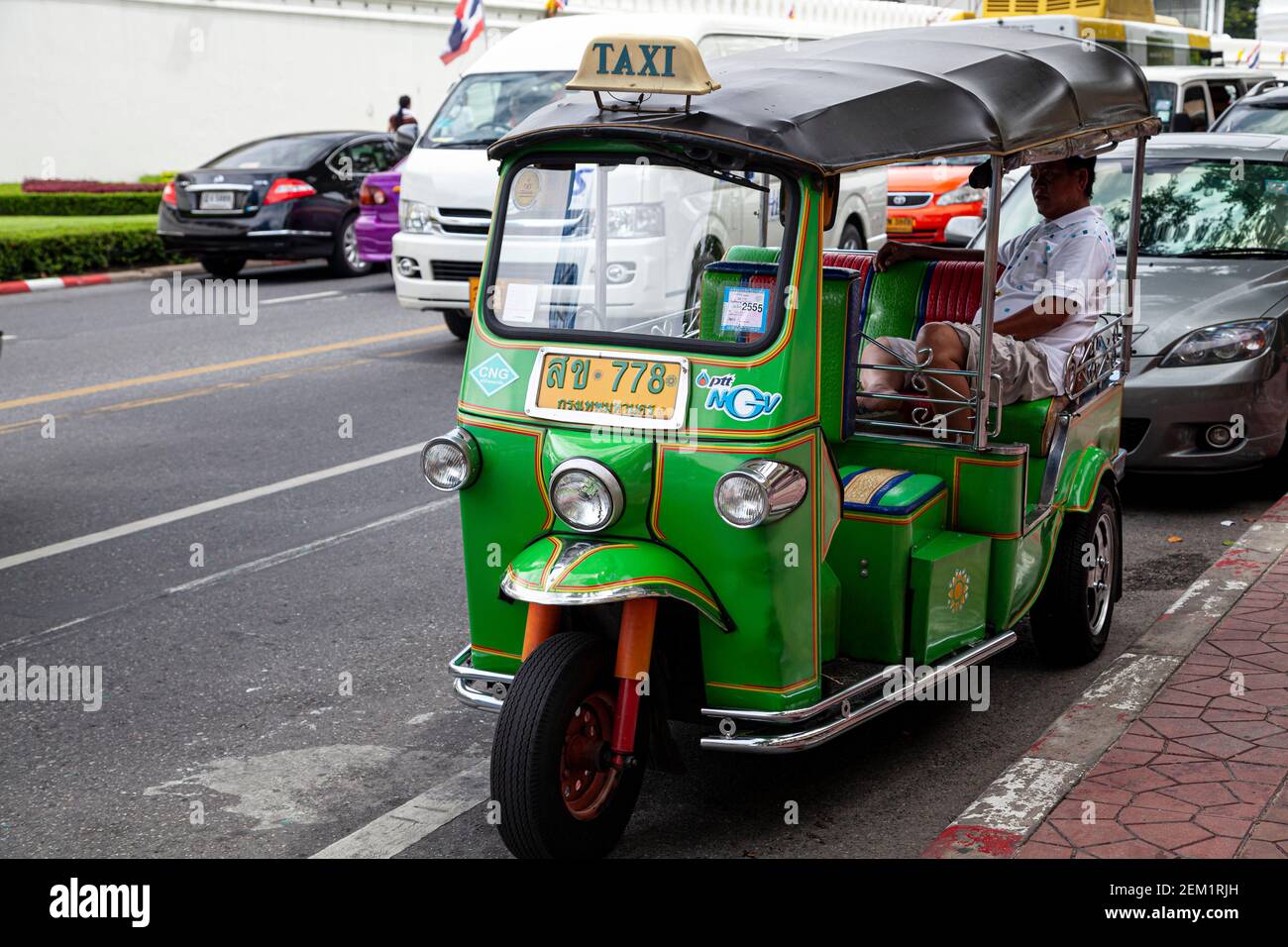 An auto rickshaw, also known as tuk tuk parked on the side of a road in ...