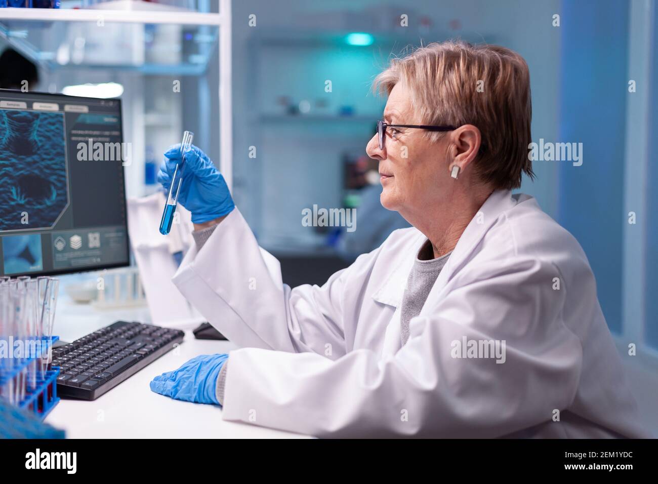 Senior scientist doctor doing research analysing liquid in test tube ...