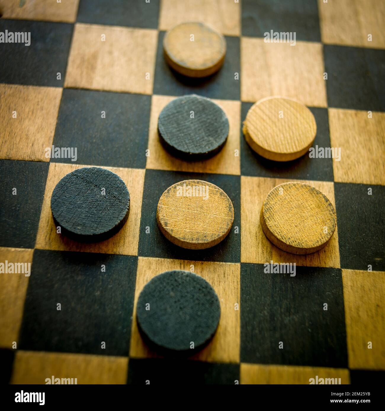 A close-up view of a checkers game in progress on a vintage wooden ...
