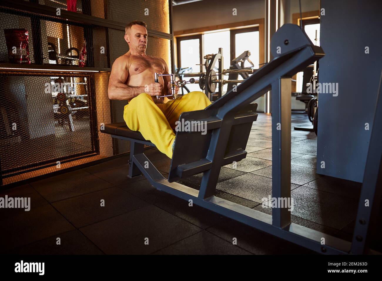 Focused guy straining while exercising at the gym Stock Photo - Alamy