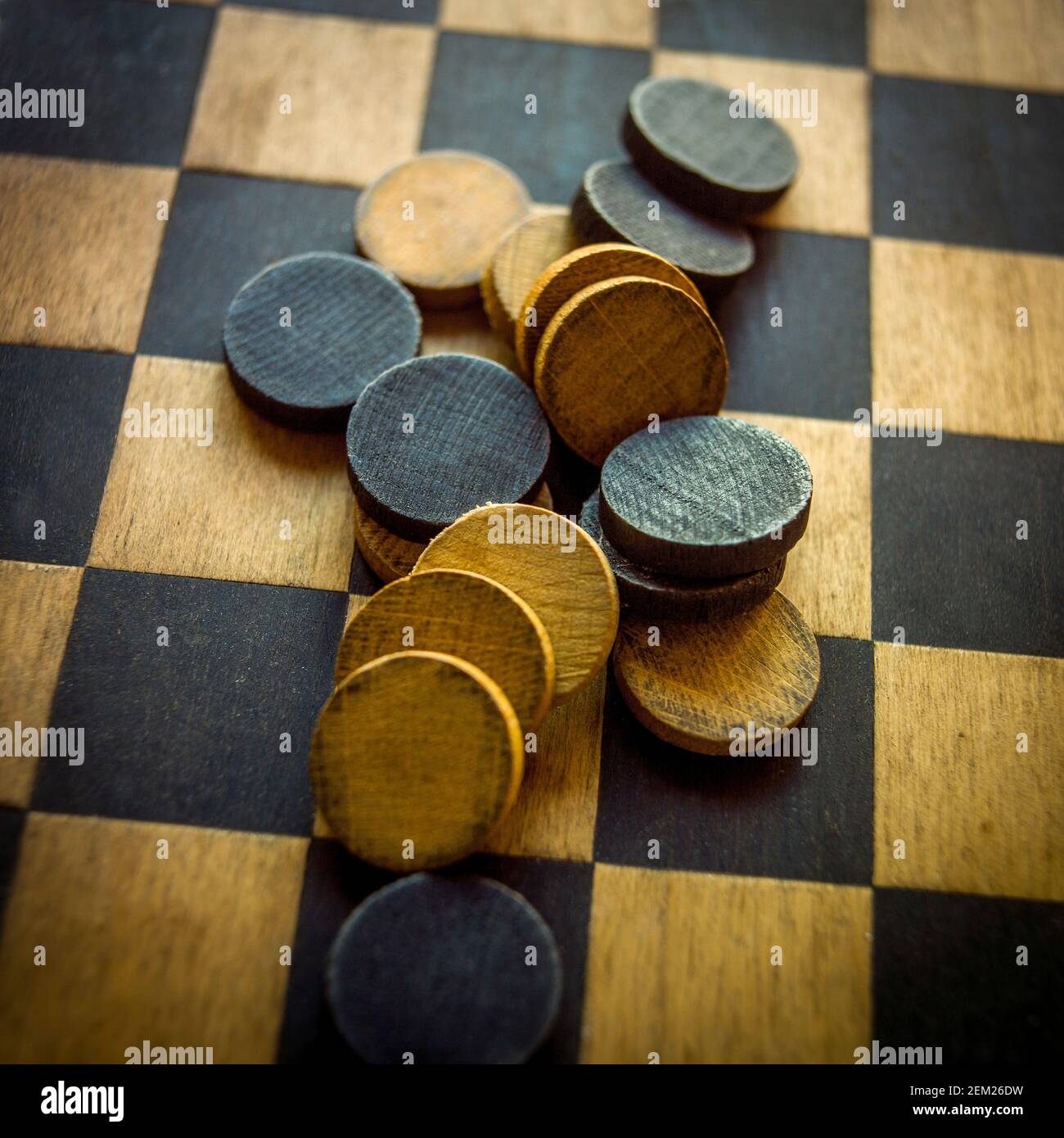 Classic wooden checkers on a checkerboard, showcasing distinct colors ...