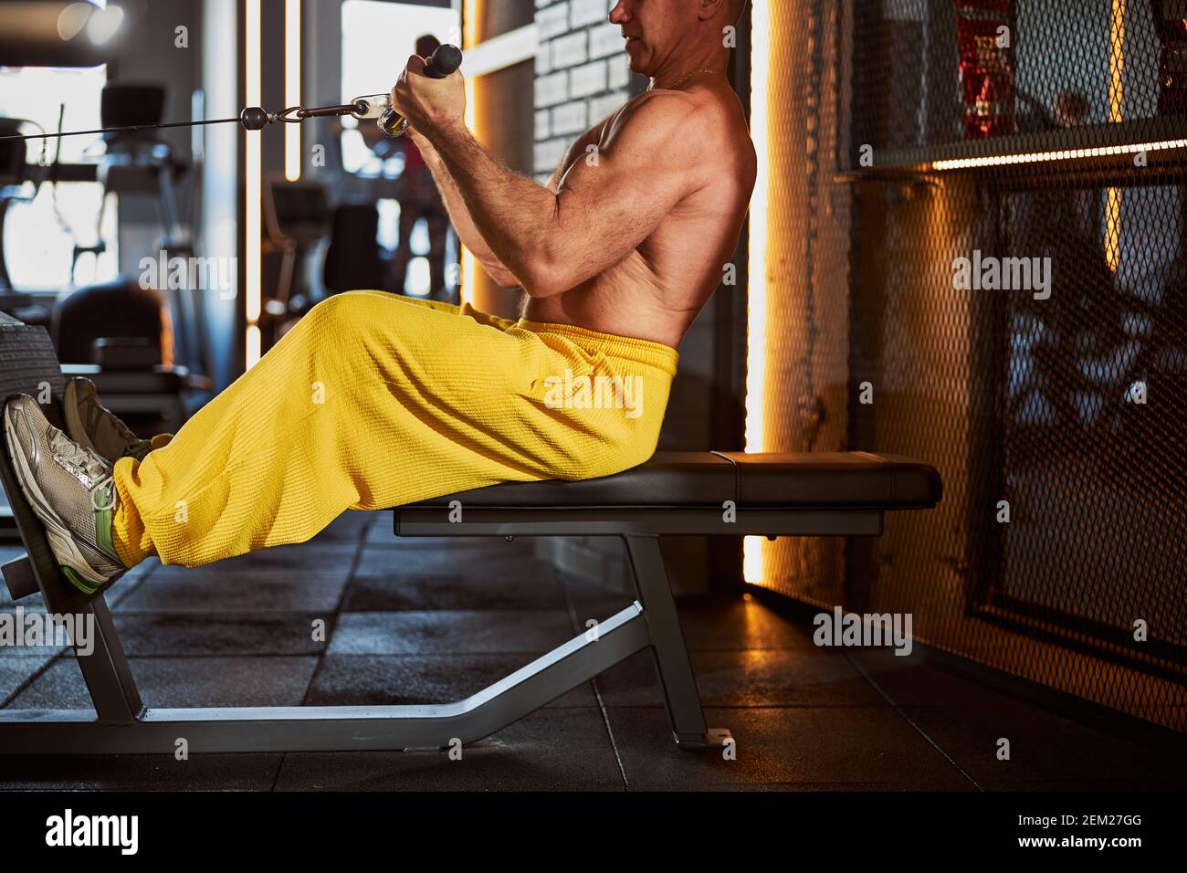 Muscular man exercising his upper body on rowing machine Stock Photo ...