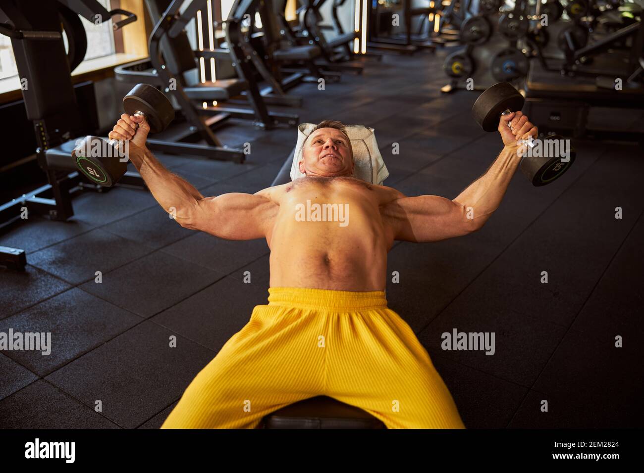 Hefty sportsman having a proper dumbbell workout Stock Photo - Alamy