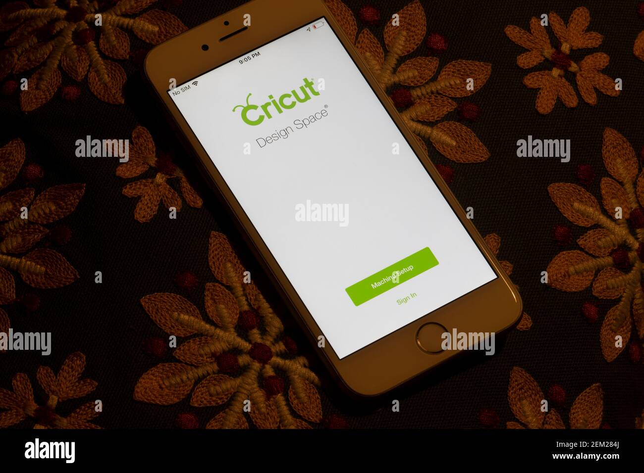 Cricut Design Space app login page is seen on an iPhone. The companion ...