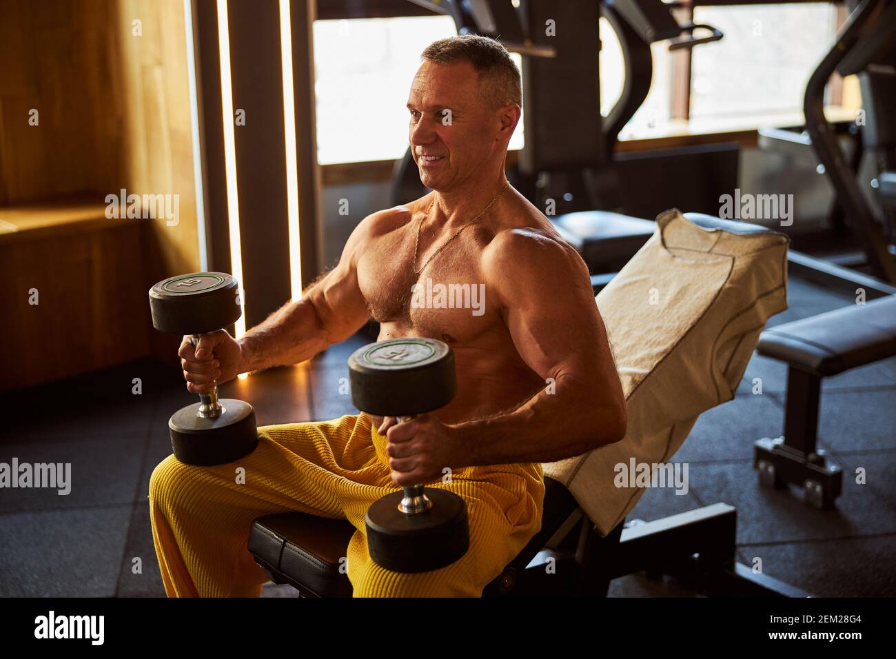 Joyous bodybuilder ready for a workout with dumbbells Stock Photo - Alamy