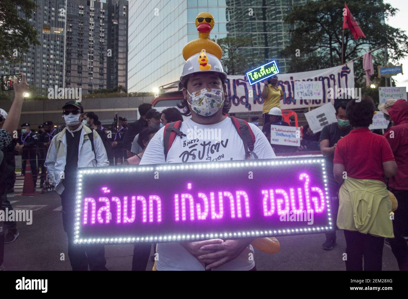A protester holds a neon light sign that reads "Very brave,Very good ...
