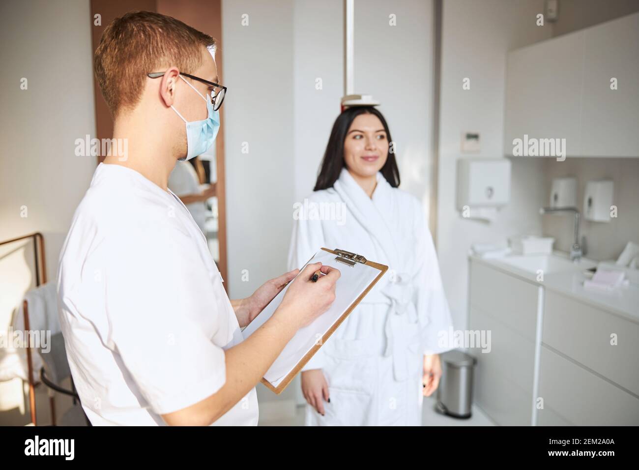 Pleased patient having her height measured at the doctor office Stock ...