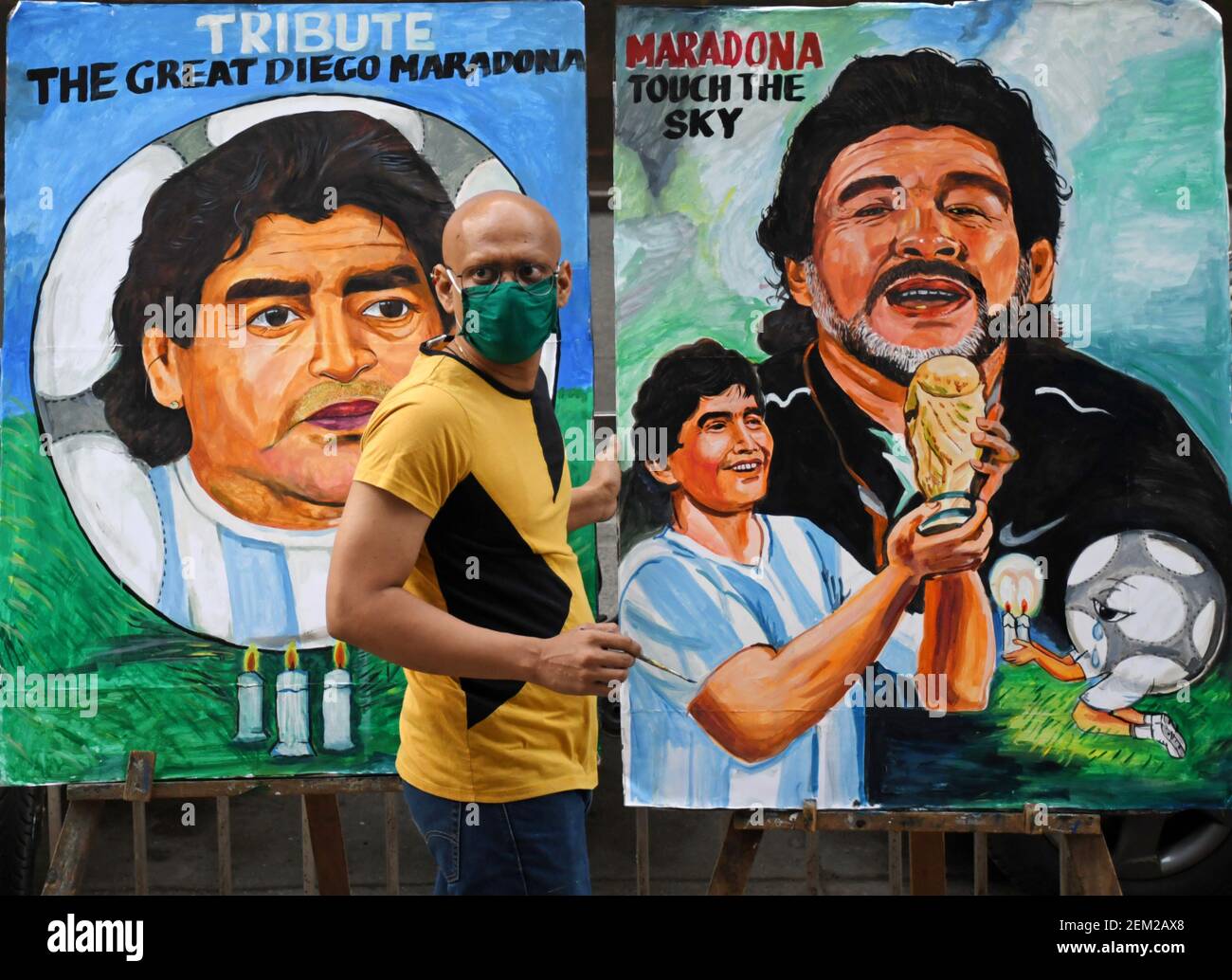An artist standing next to a graffiti of the footballer player, Diego ...