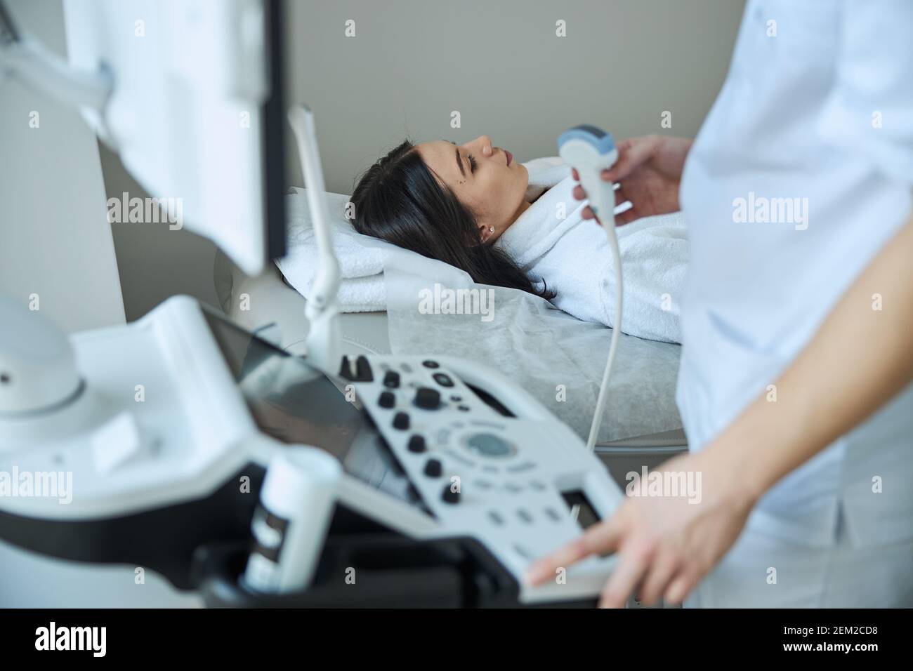 Experienced male doctor performing a diagnostic sonography procedure ...