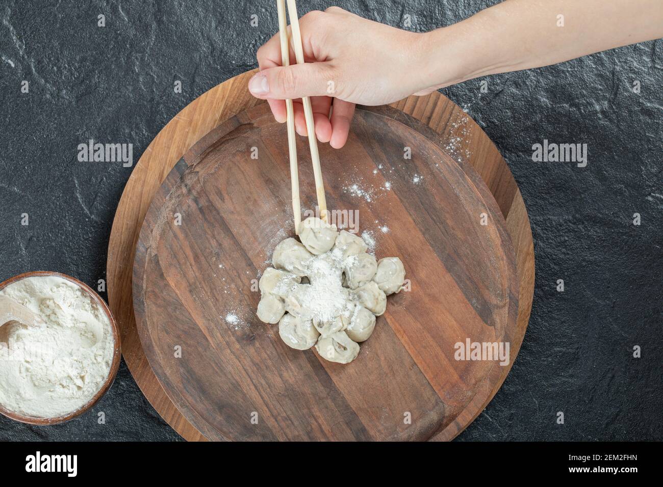 Female hand taking dumpling with chopsticks from plate Stock Photo - Alamy