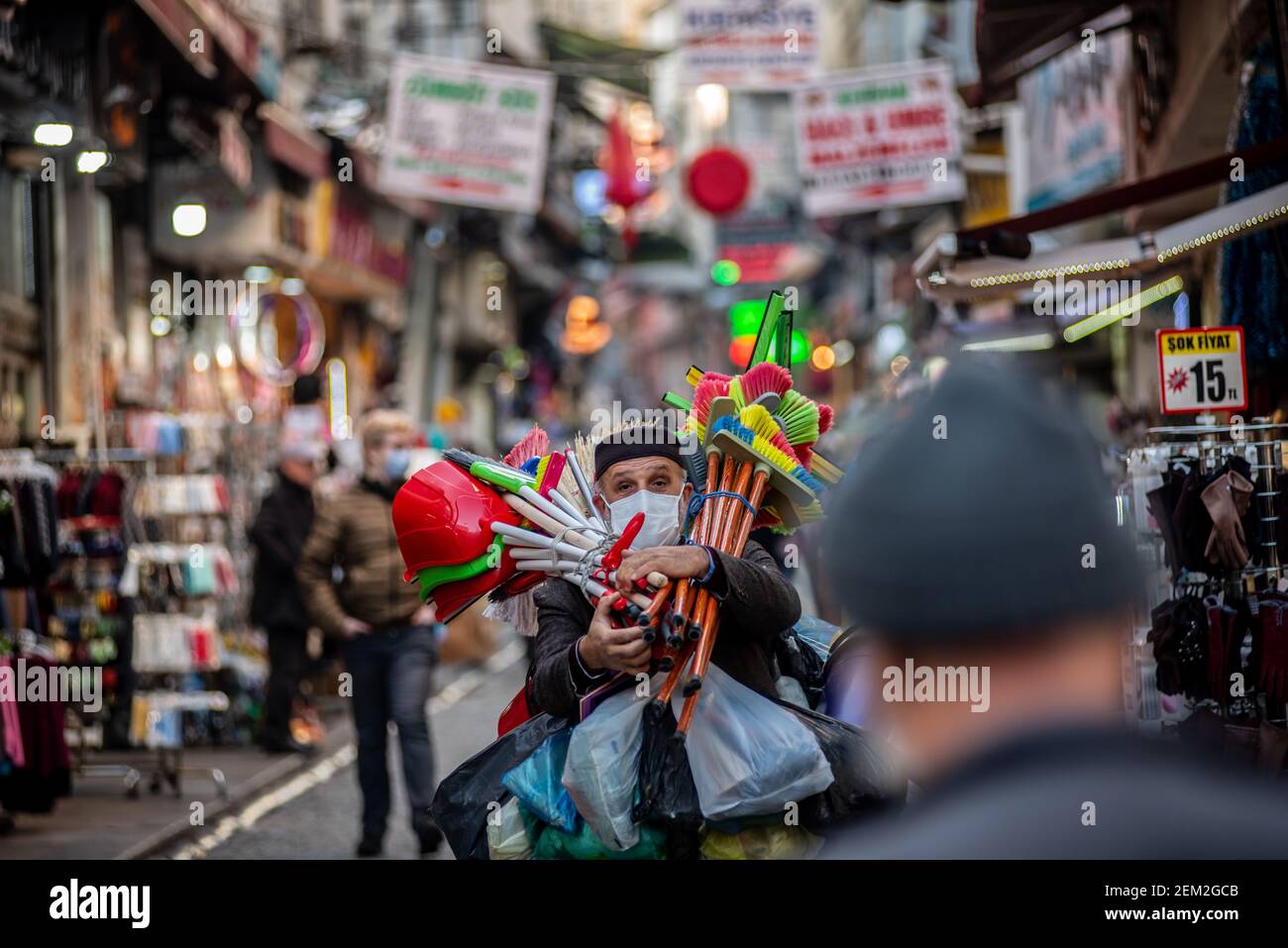 A vendor selling household wares seen wearing a face mask as a ...