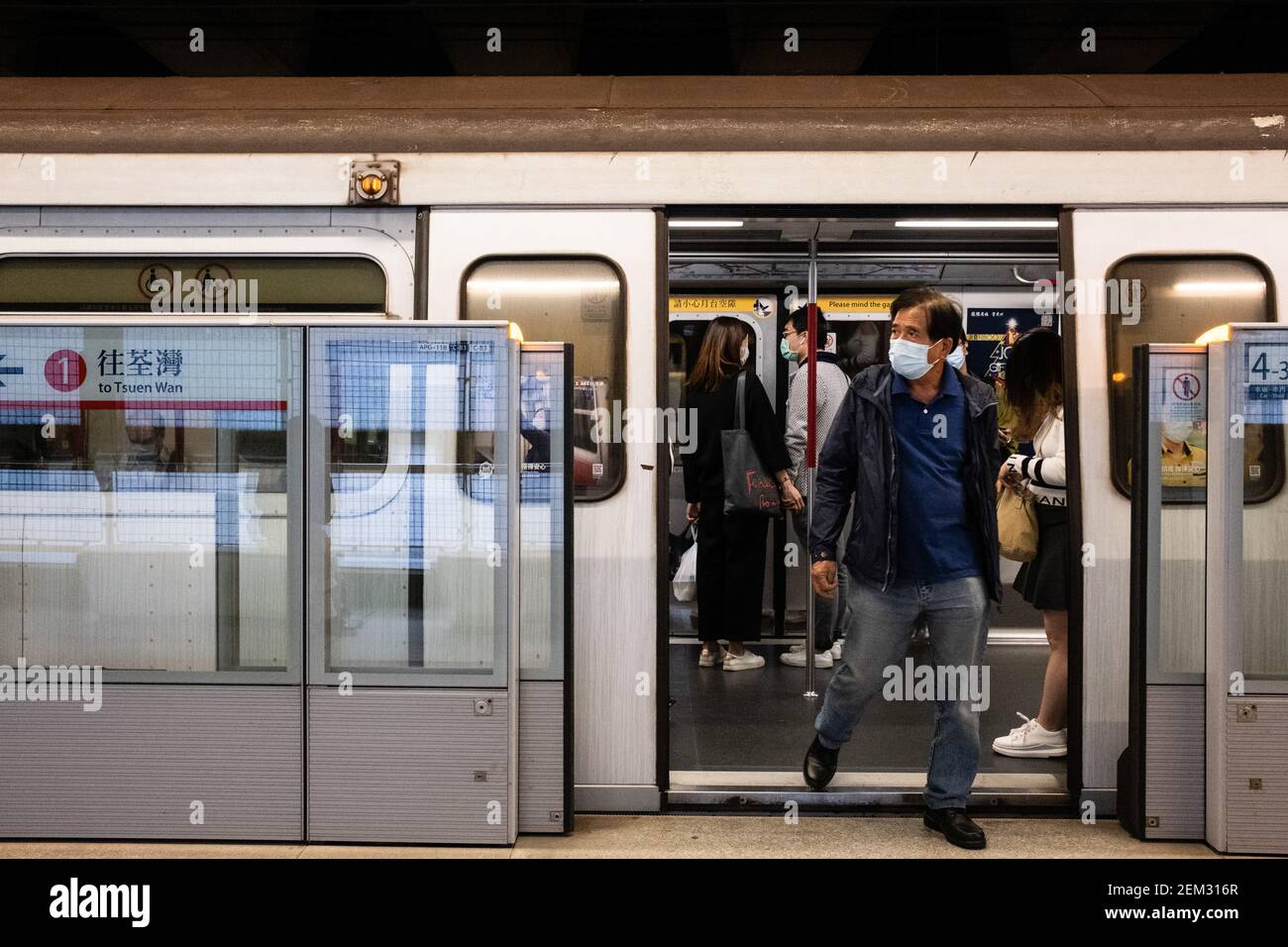 Passengers wearing face masks leave a MTR subway train. Hong Kong ...