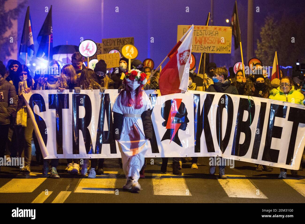 Protesters hold a banner and placards during the Women's Strike. 'You ...