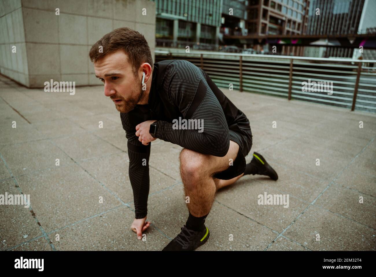 Caucasian male athlete preparing to run kneeling on ground Stock Photo ...