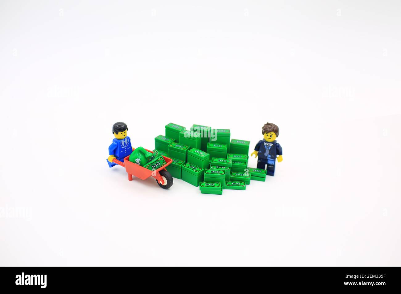 lego man pay the money to the poor guy Stock Photo - Alamy