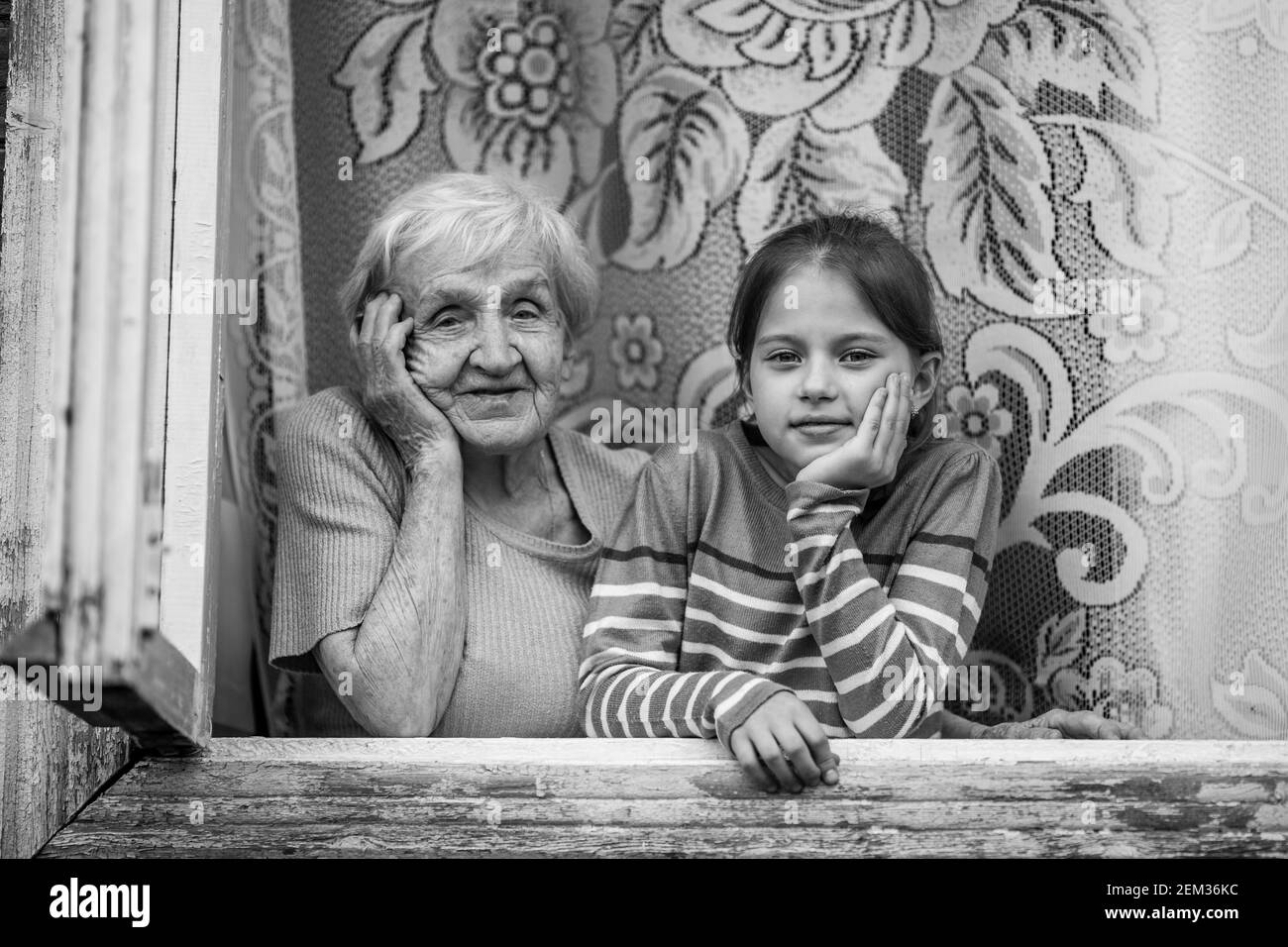 An old woman granny and her granddaughter together to look out the ...