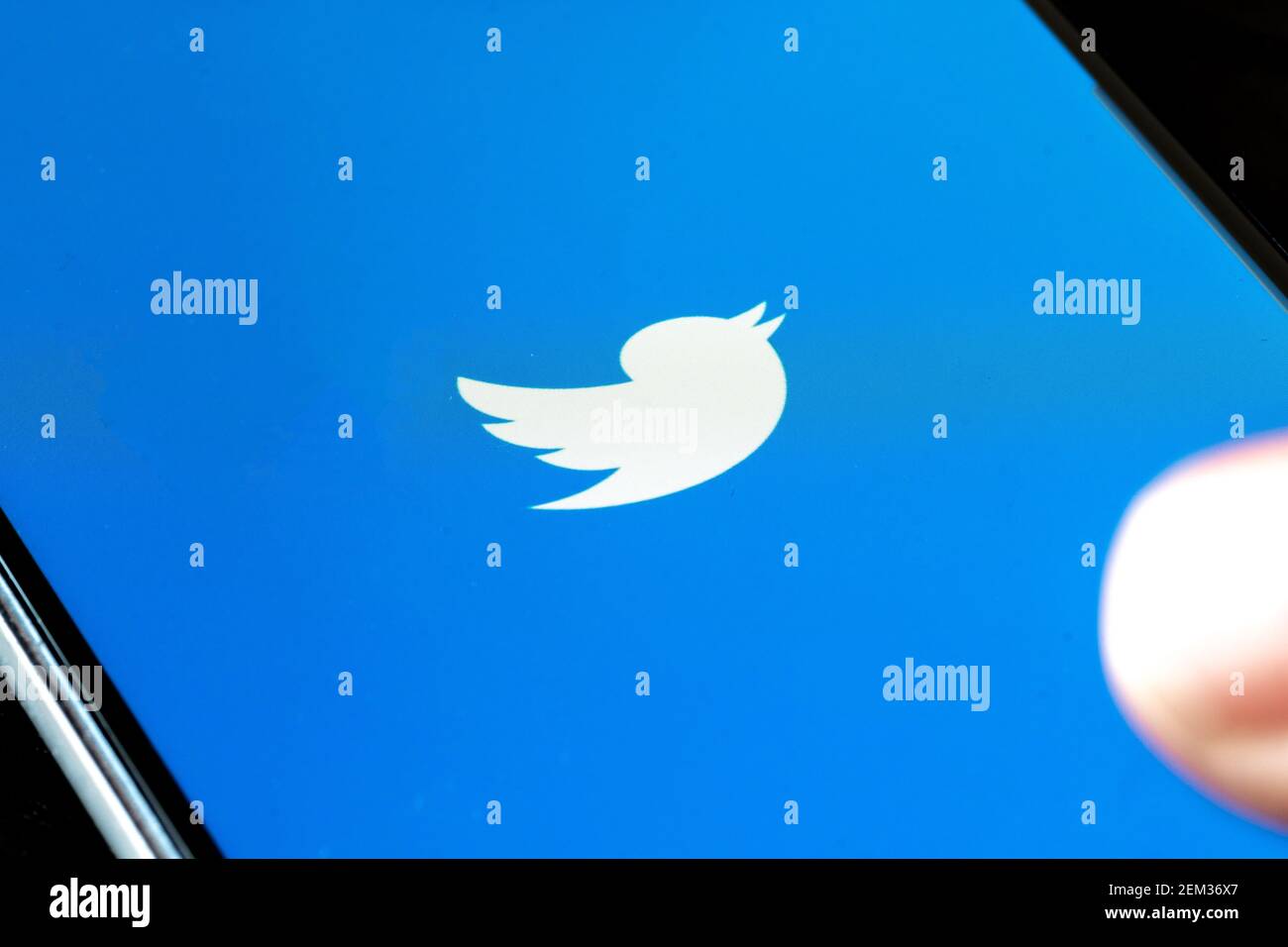 Twitter app displayed on the smartphone with finger. Twitter one of the ...