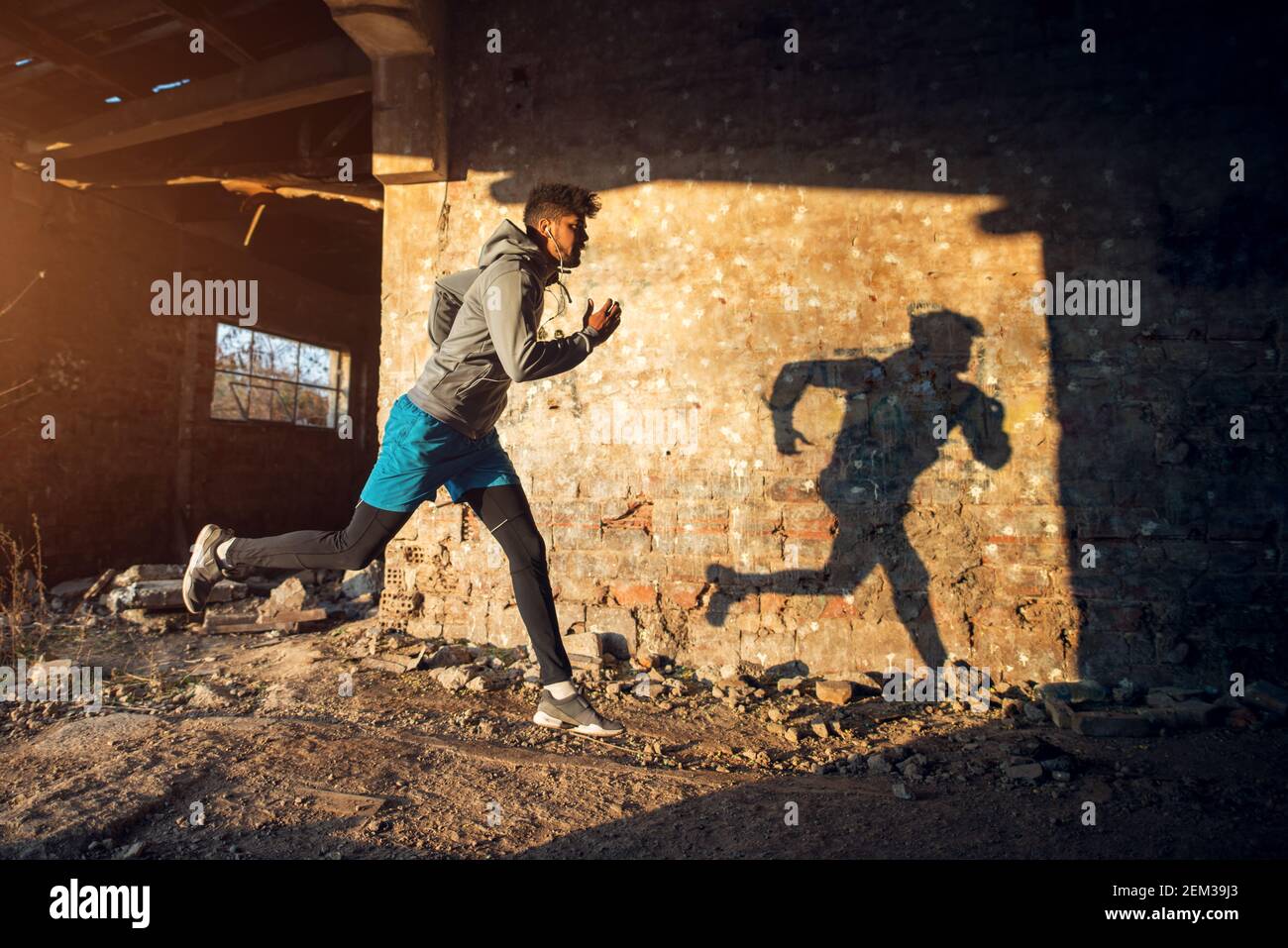 Side view of sporty active afro american runner man running with shadow ...