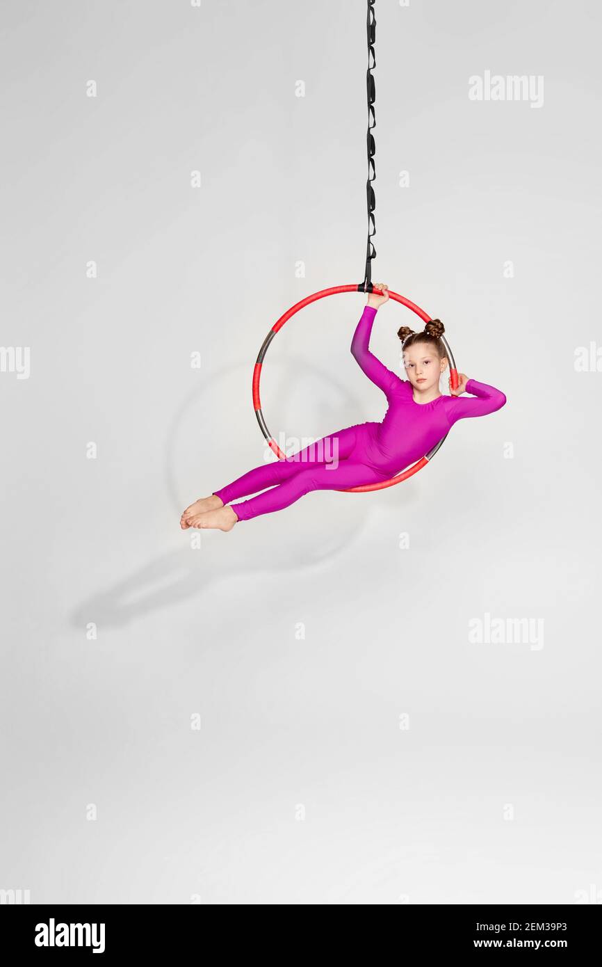 little child girl gymnast in pink sportwear shows an acrobatic ...