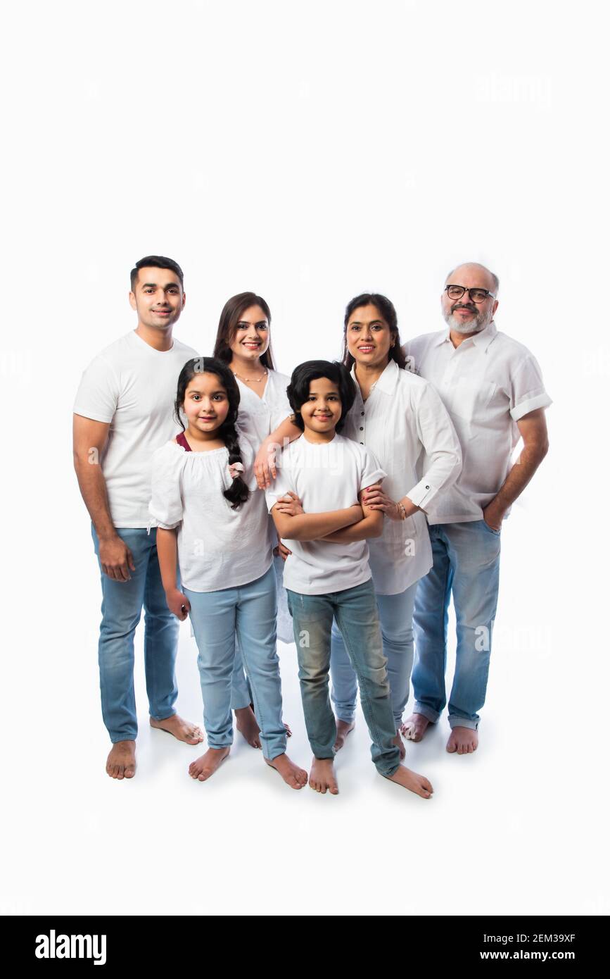 Indian multigenerational family in white cloths standing and looking at ...