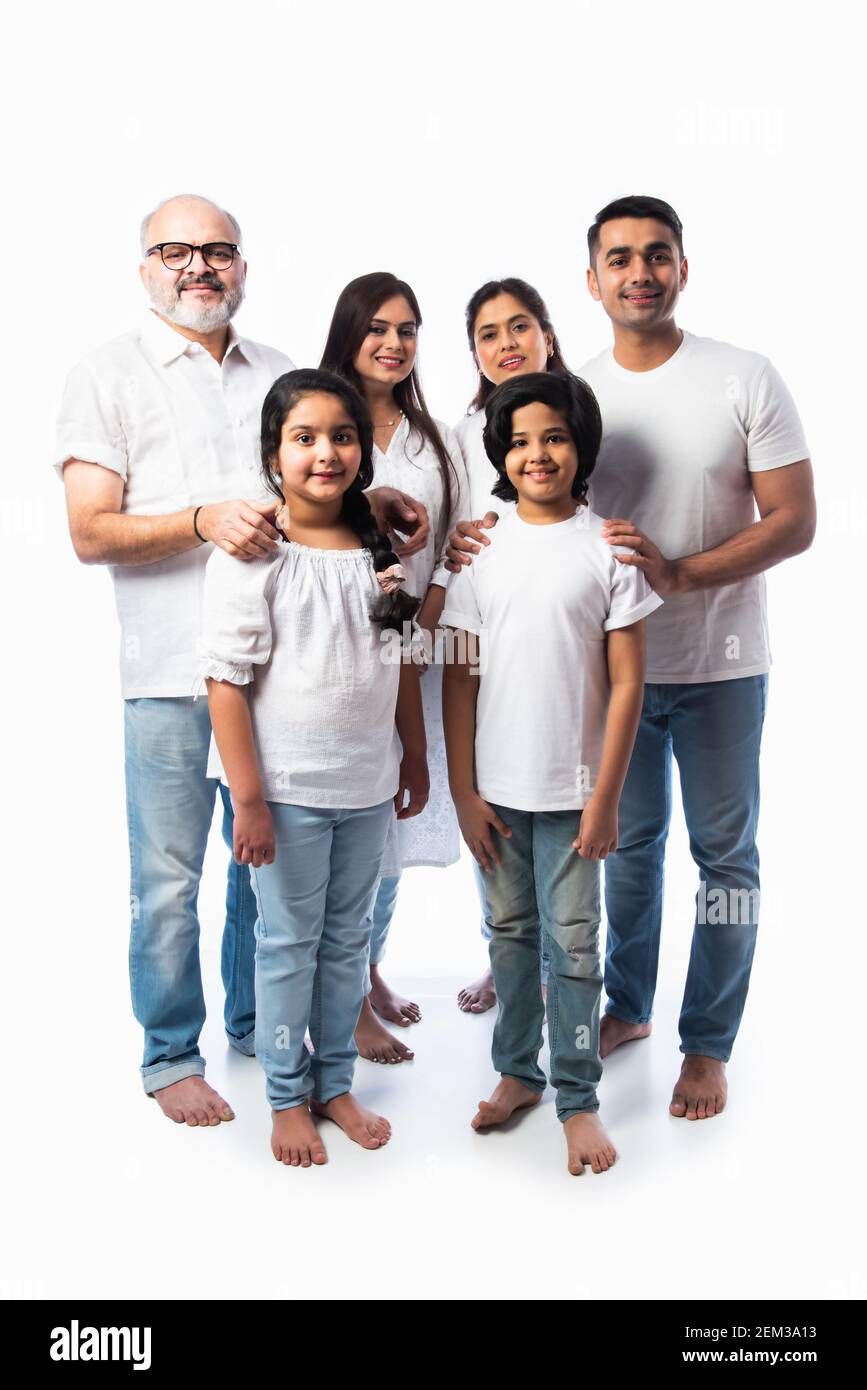 Indian multigenerational family in white cloths standing and looking at ...