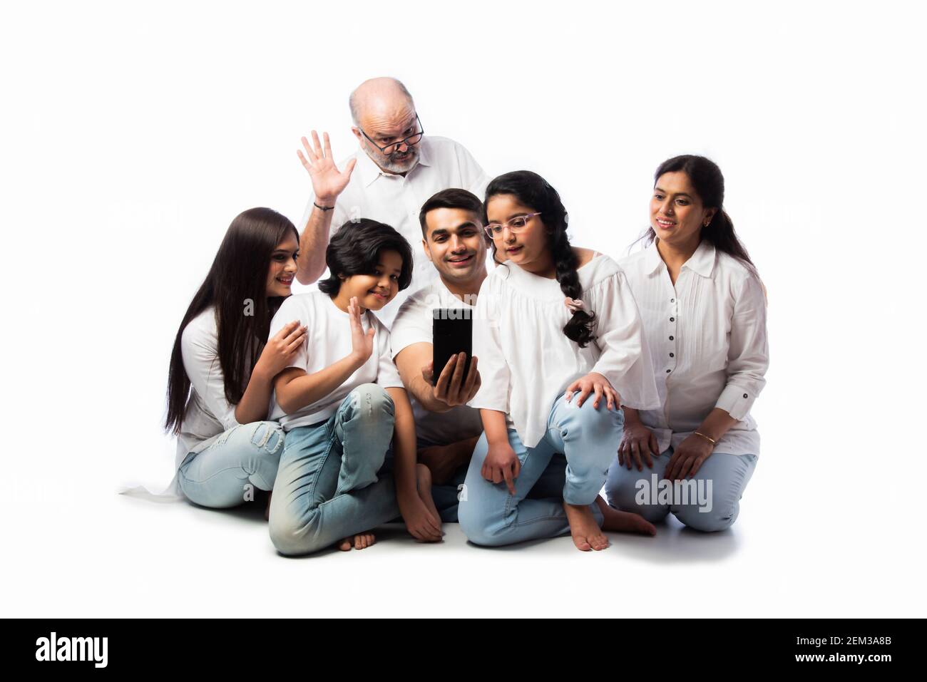 Indian family of six video calling on smartphone or taking selfie ...