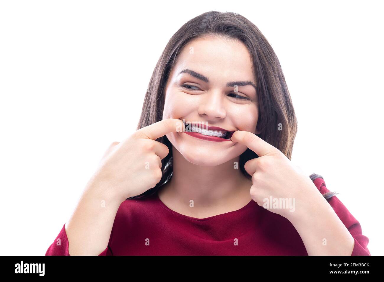 Beautiful young woman showing her teeth with braces by stretching her ...