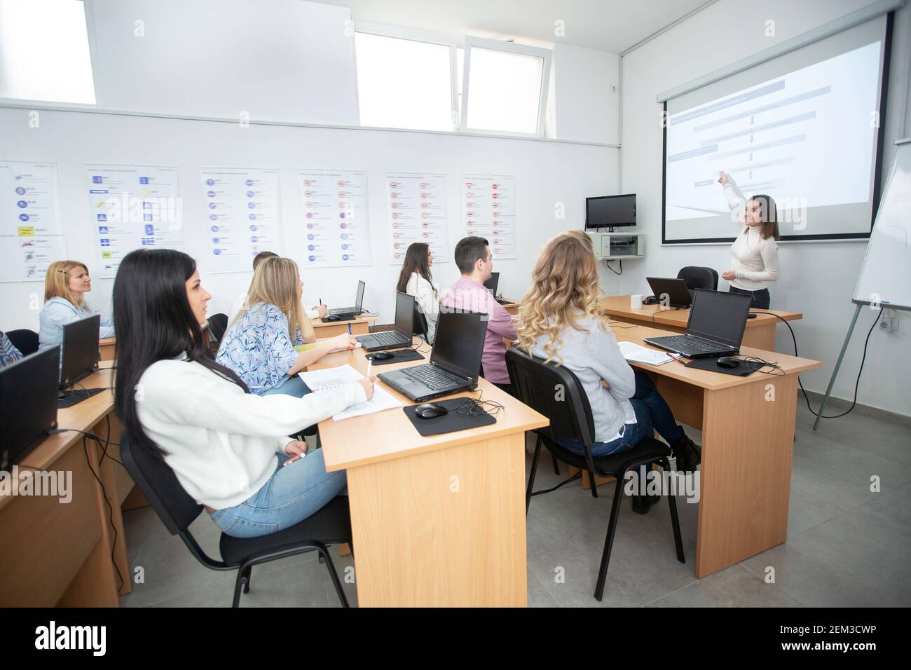 Female driving coach teaching future drivers about traffic in a ...