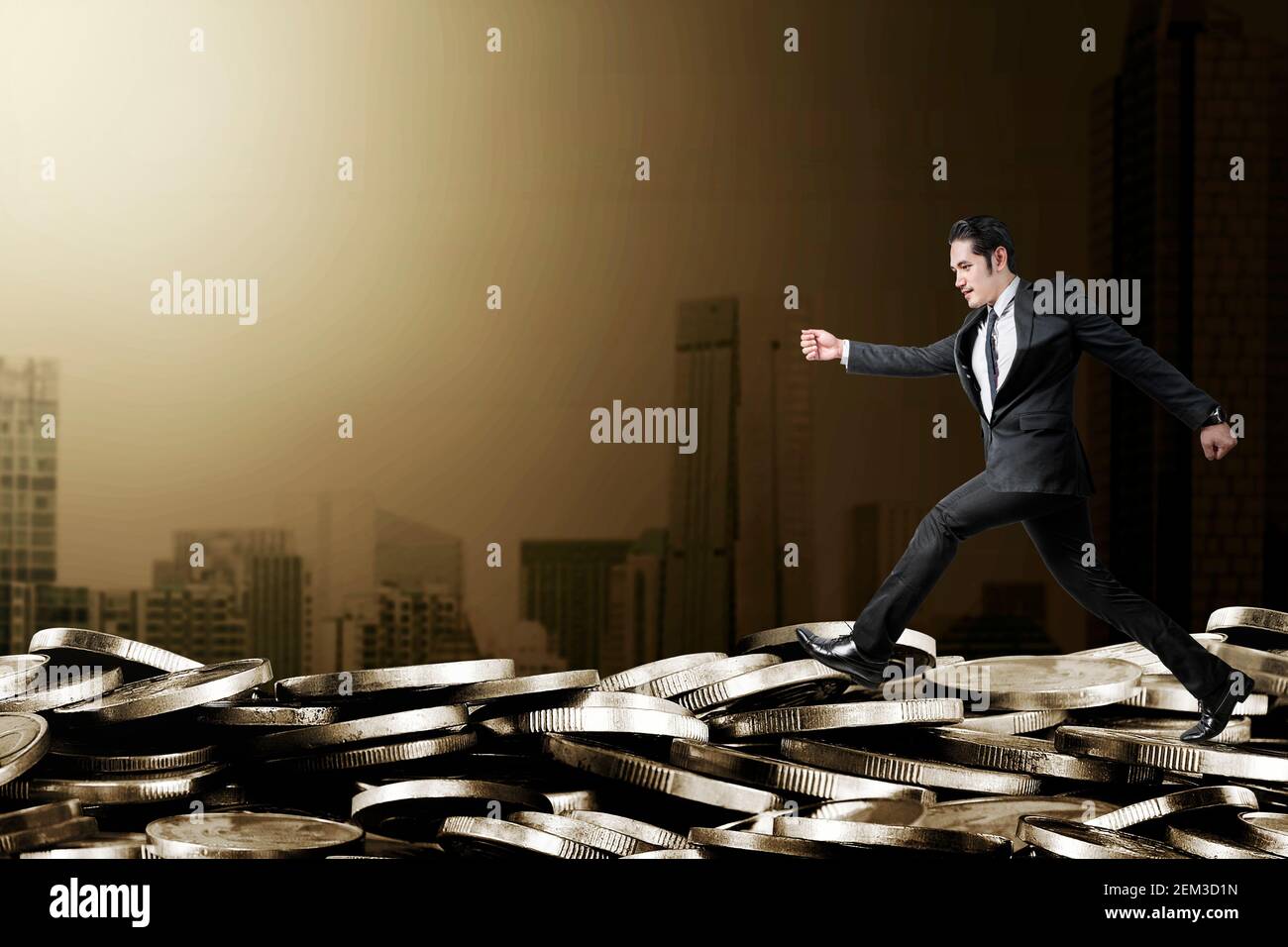 Asian businessman running on a coin stack Stock Photo - Alamy