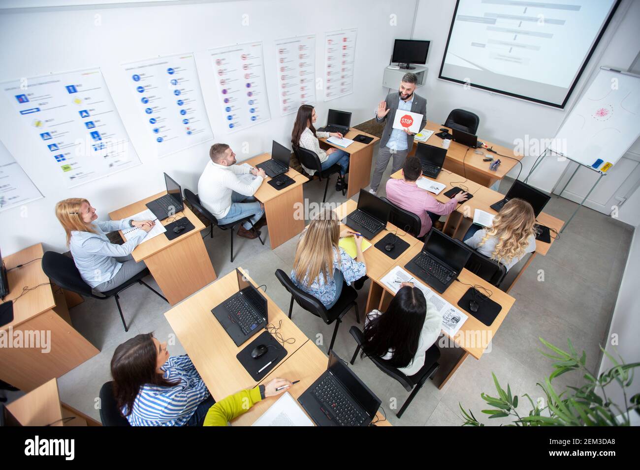 Driving instructor holding and showing a STOP sign representation on ...