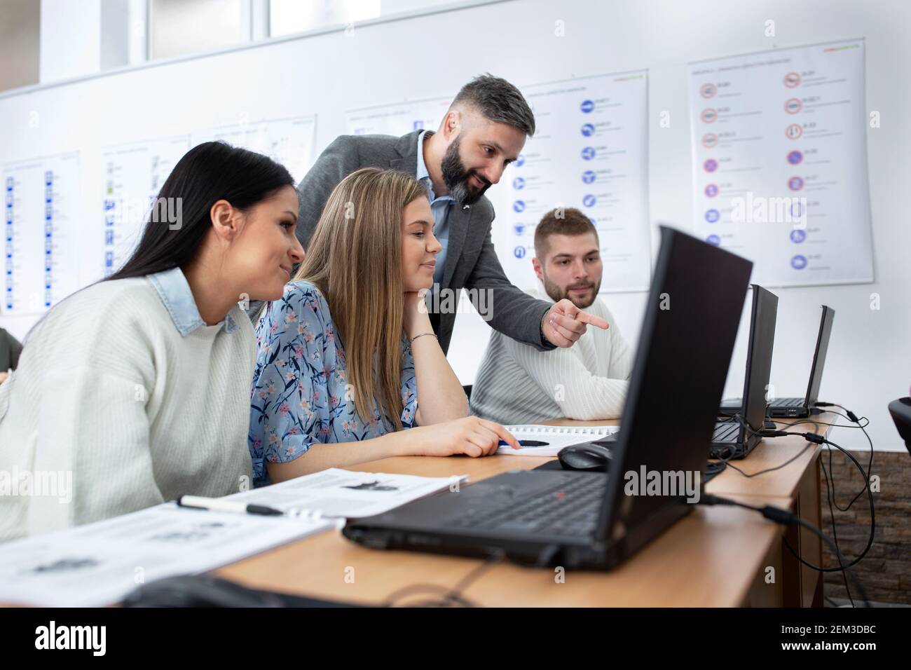 Driving theory teacher showing his students traffic rules in the ...
