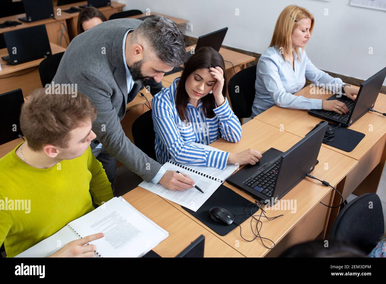 University professor lecturing small group of students in the classroom ...