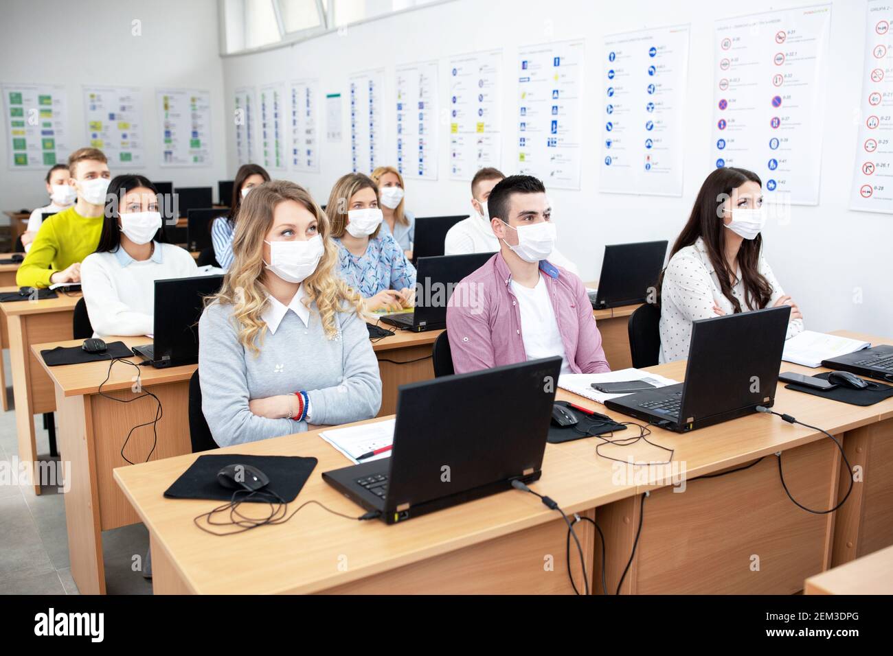 Group of students wearing protection masks in class, prevention concept ...