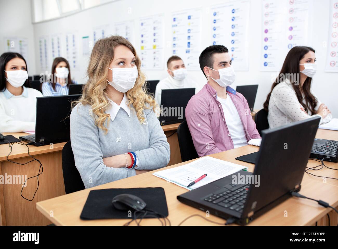 Group of students wearing protection masks in class, prevention concept ...