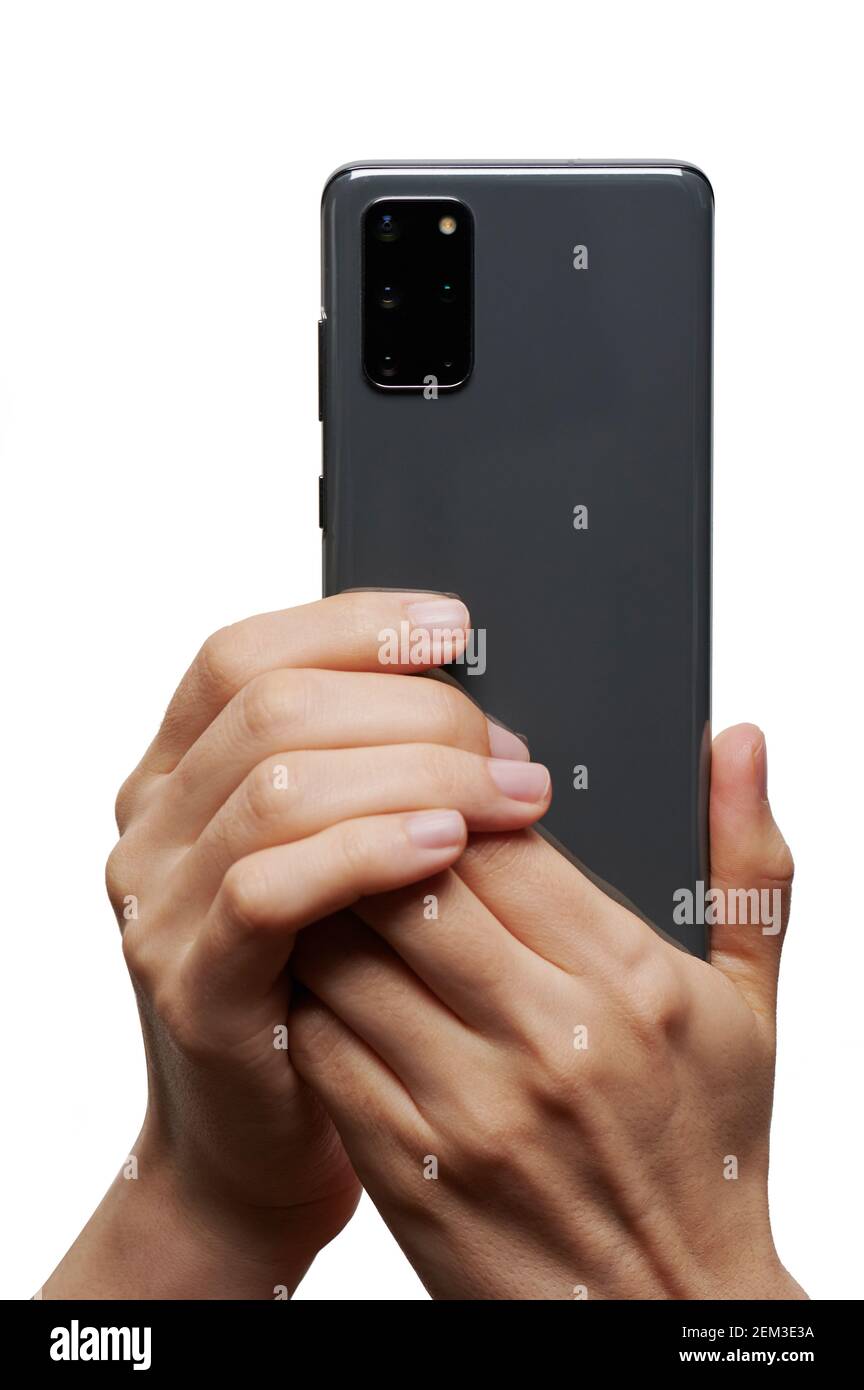 Holding smartphone steady with two hands isolated on white studio ...