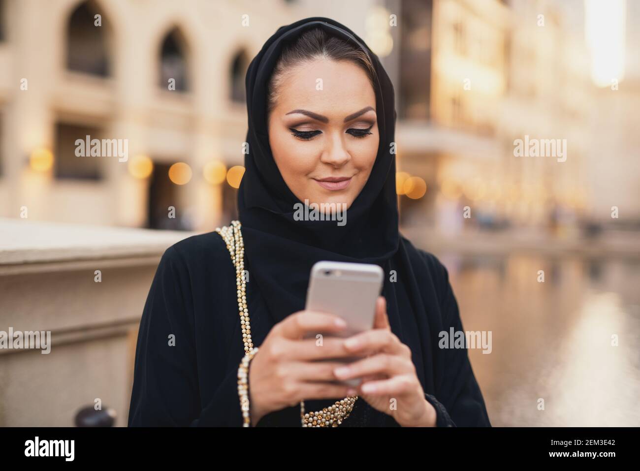 Gorgeous woman smiling while texting her friend on her phone Stock ...