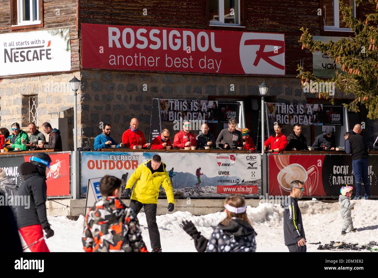 Ski instructors and teachers having a lunch break in sunny weather at ...